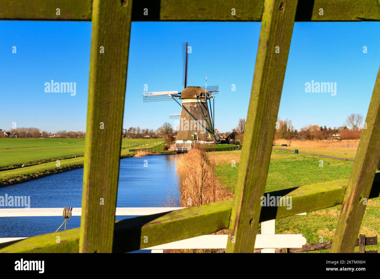 Rural landscape - view of a canal on a background of a mill on a sunny ...