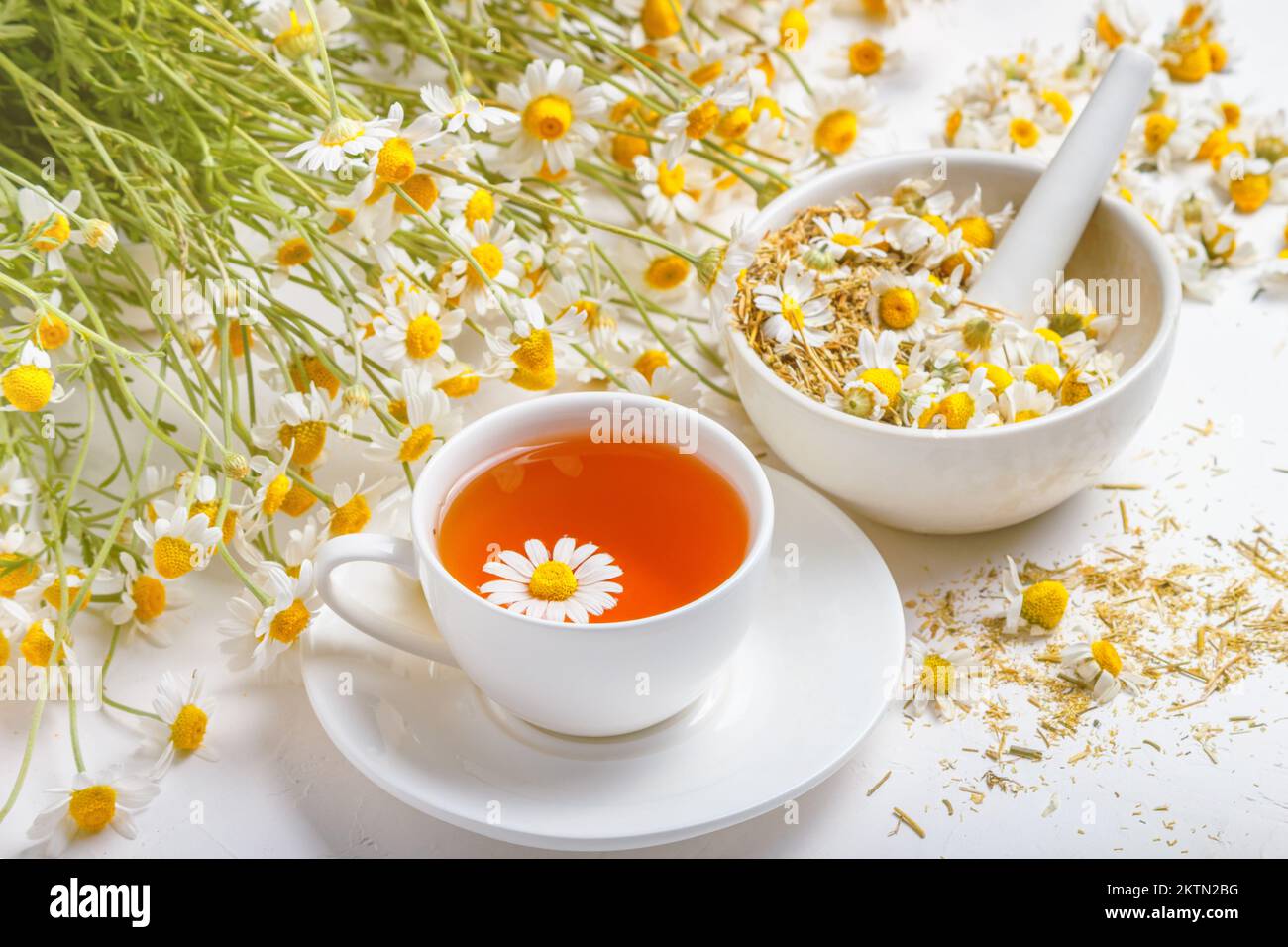 Daisy flowers in white tea cup, healthy chamomile herbs and mortar of ...