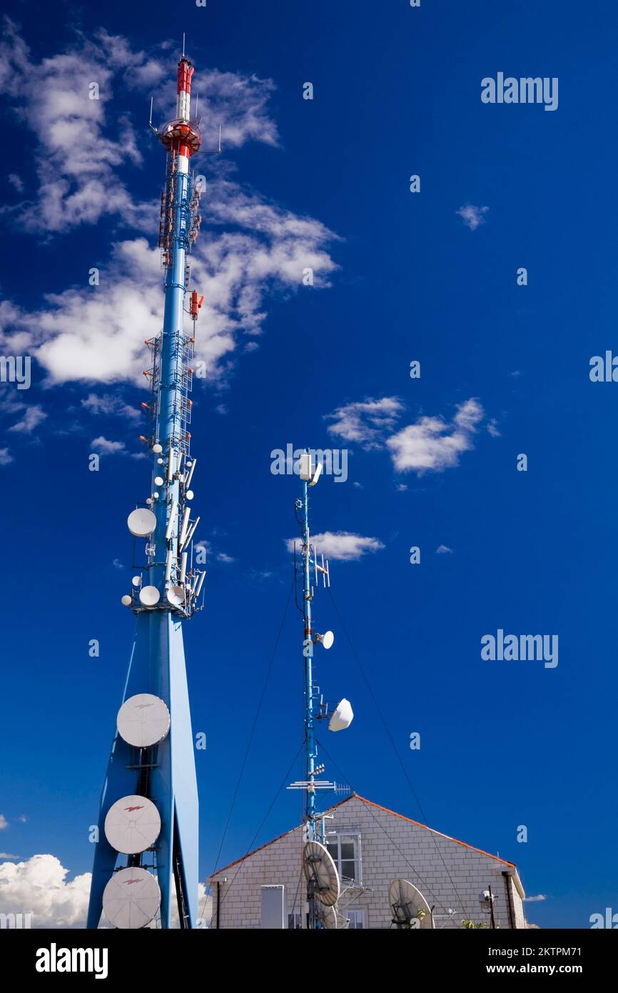 Mobile phone communications towers against blue sky with white cumulus clouds, Mount Srd ...