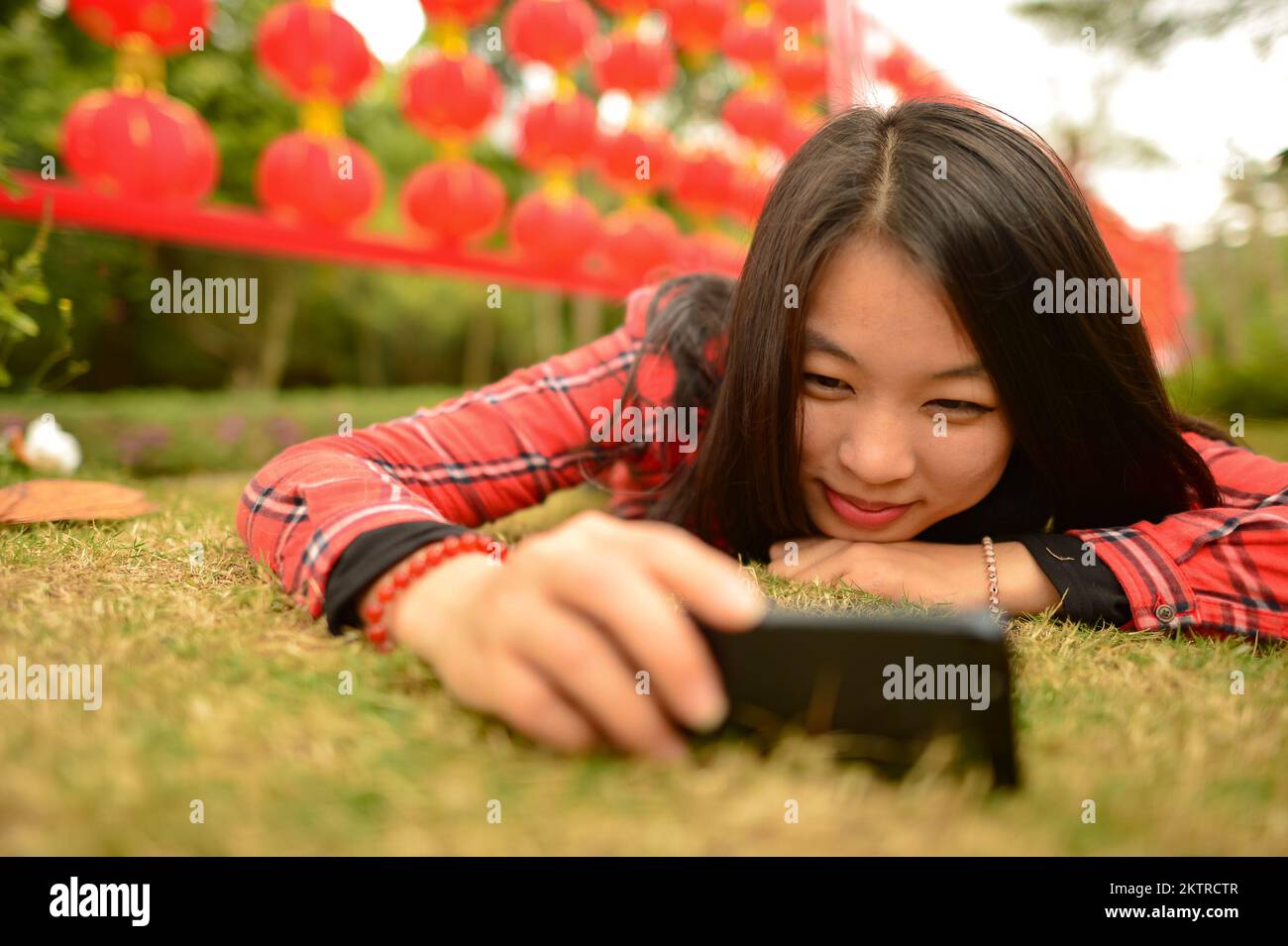 Chinese woman use smartphone in the park during chinese new year Stock ...