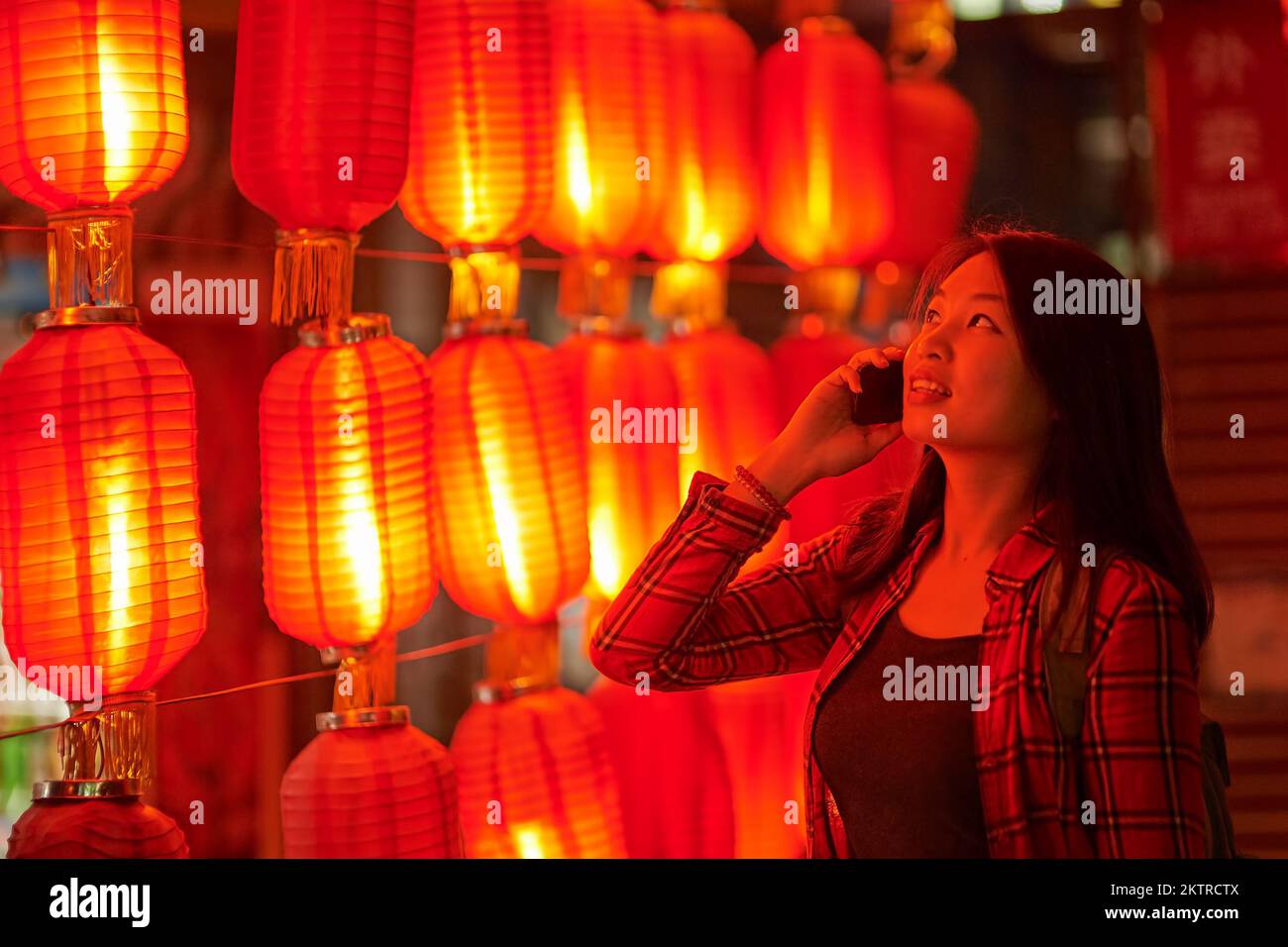 Chinese teenager with cell phone near chinese new year lanterns Stock ...