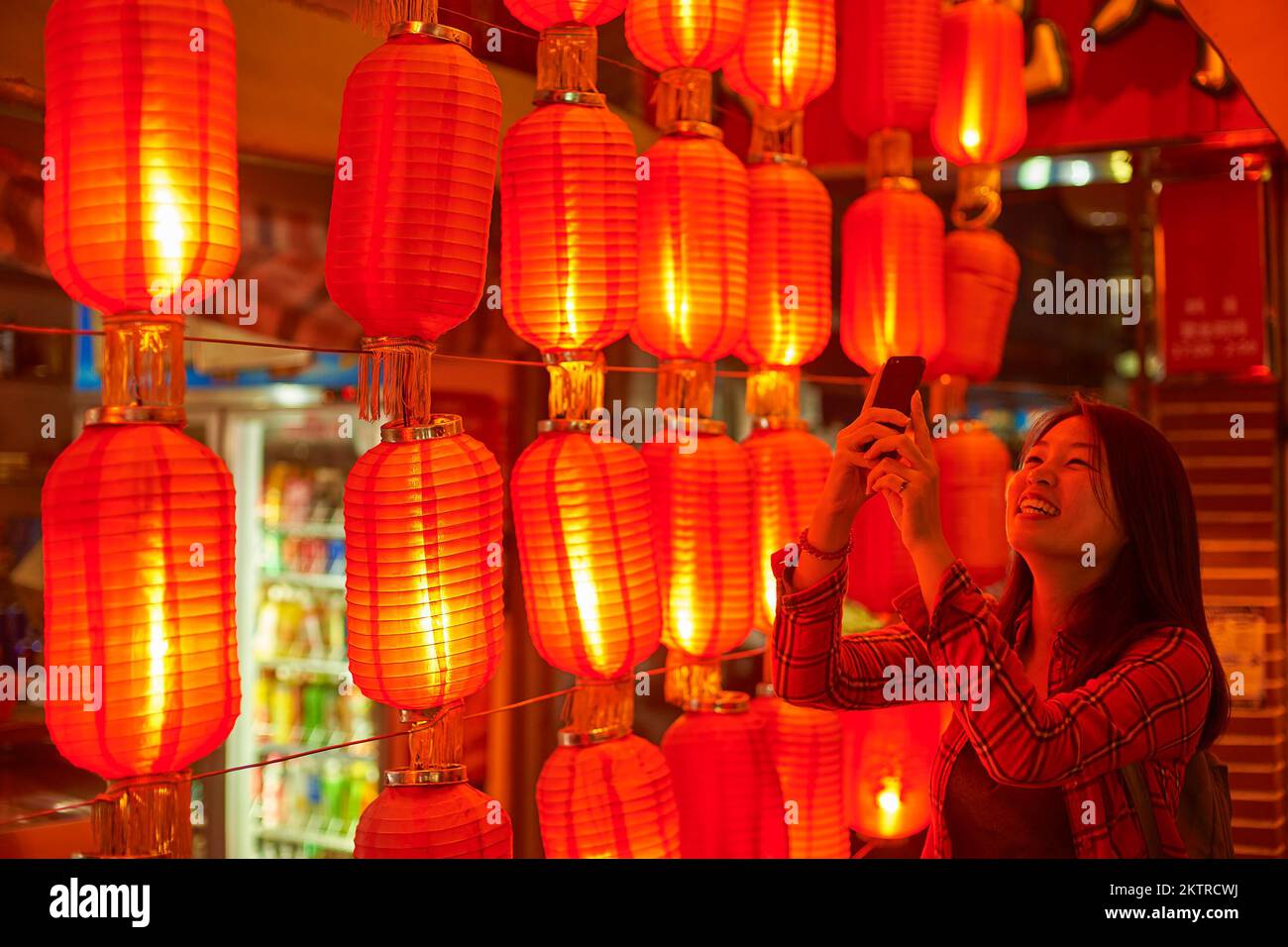 Chinese teenager with cell phone near chinese new year lanterns Stock ...