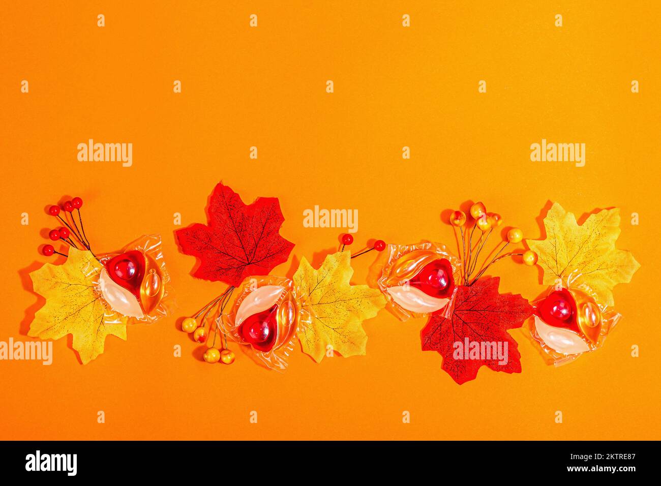 Machine washing concept. Capsules with detergent and autumn decor ...