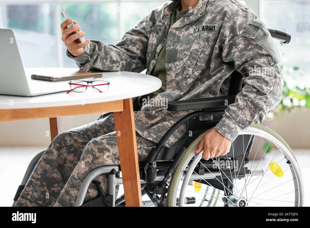 Young soldier in wheelchair using mobile phone at home Stock Photo - Alamy