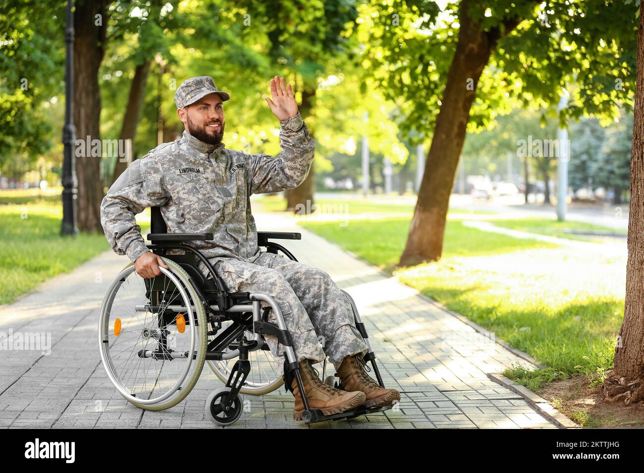 Young soldier in wheelchair waving hand outdoors Stock Photo - Alamy