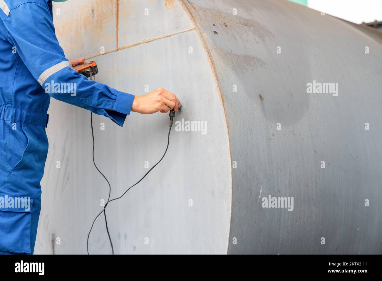 Engineering inspect the thickness wall of tanks with a device while ...