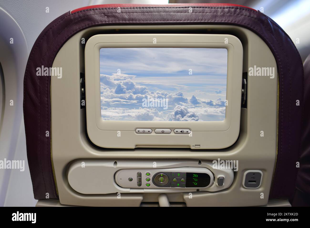 Entertainment system in modern jet flight interior. Clouds on screen is ...