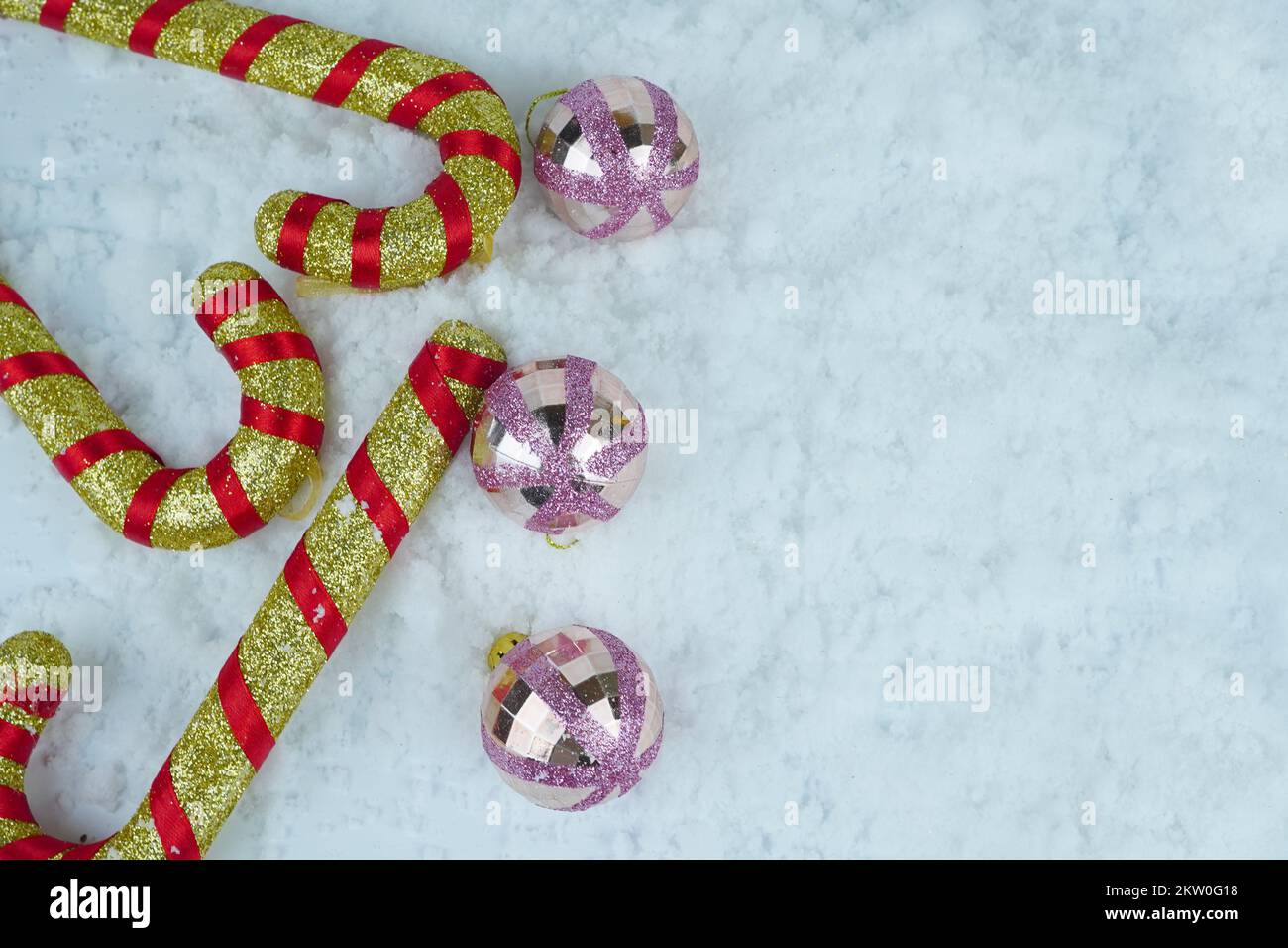 Gold and red candy canes with glitter Christmas baubles on the snow ...