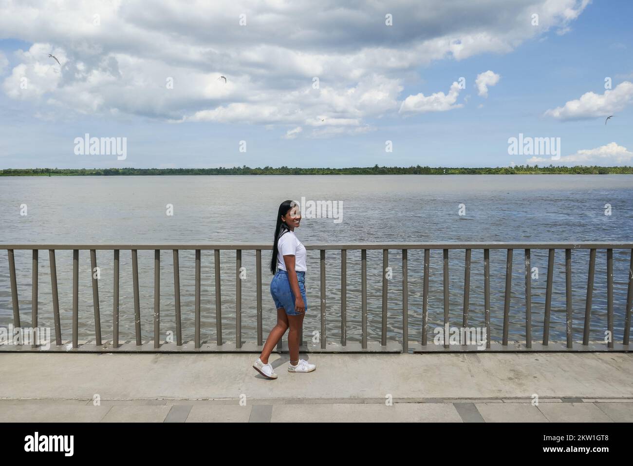 Tourist walking along the promenade and the Magdalena river ...