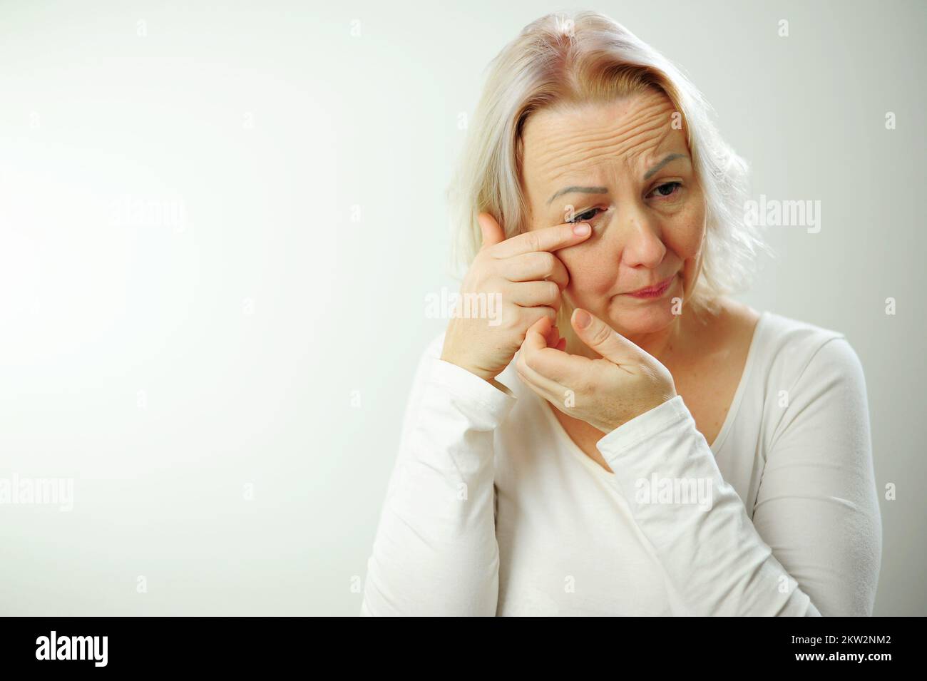 Finger wipes away tears sadness disorder Woman with white hair pressed ...