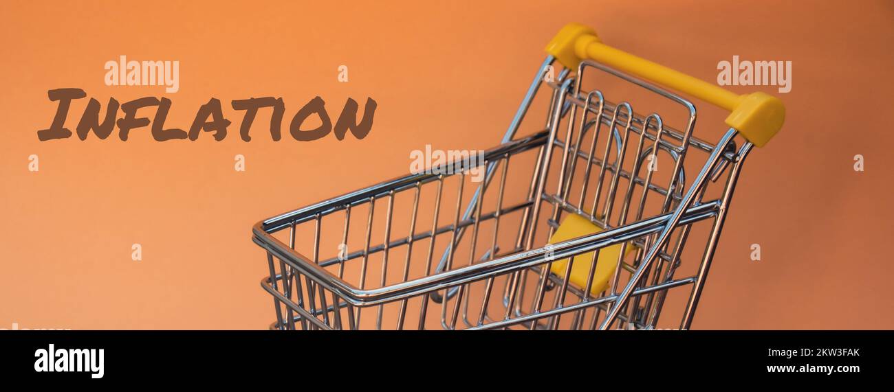 INFLATION text against Empty shopping trolley cart on beige background ...