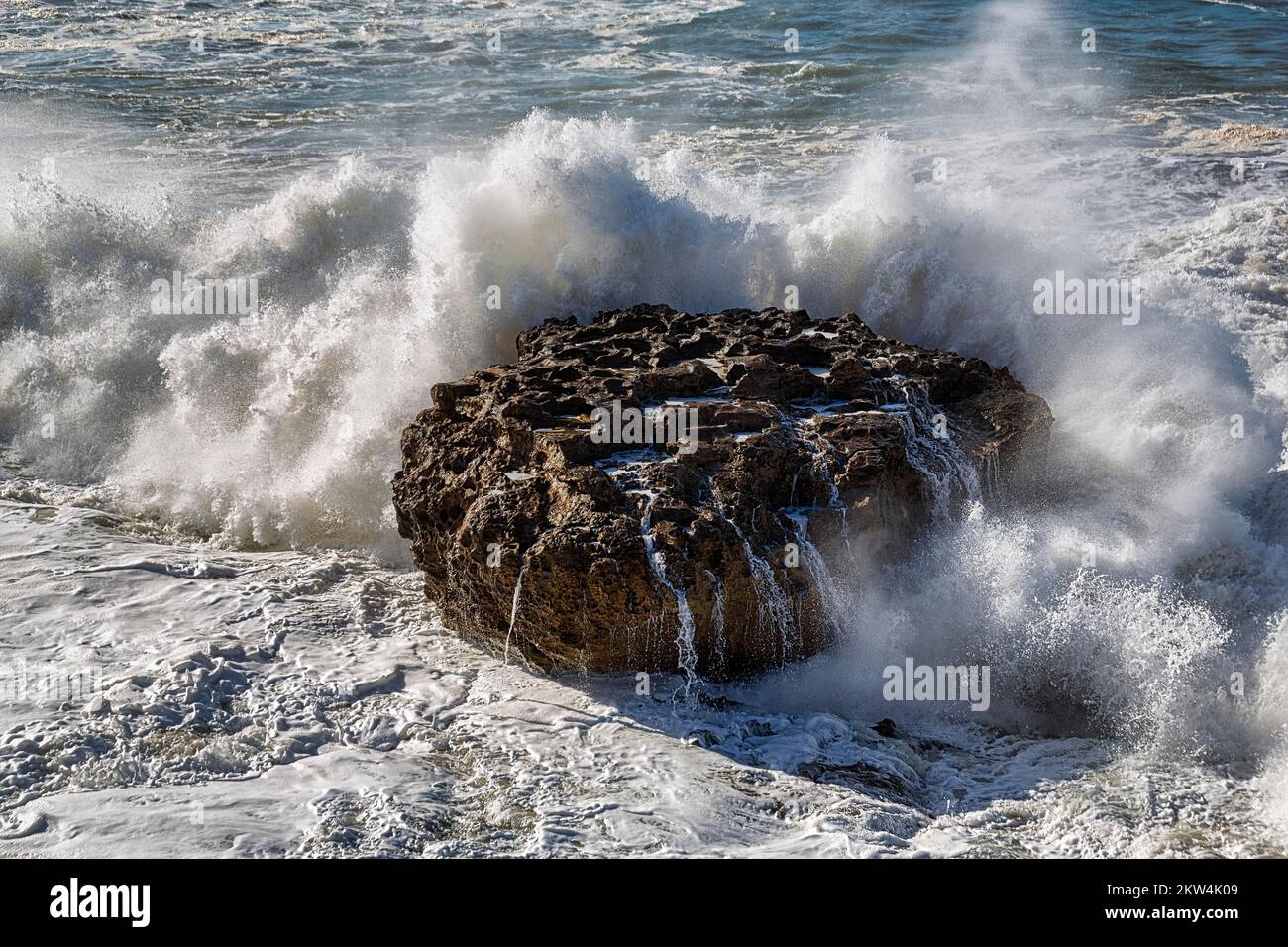 Rock in the surf, spray splashes, idiom, symbol strength, perseverance ...