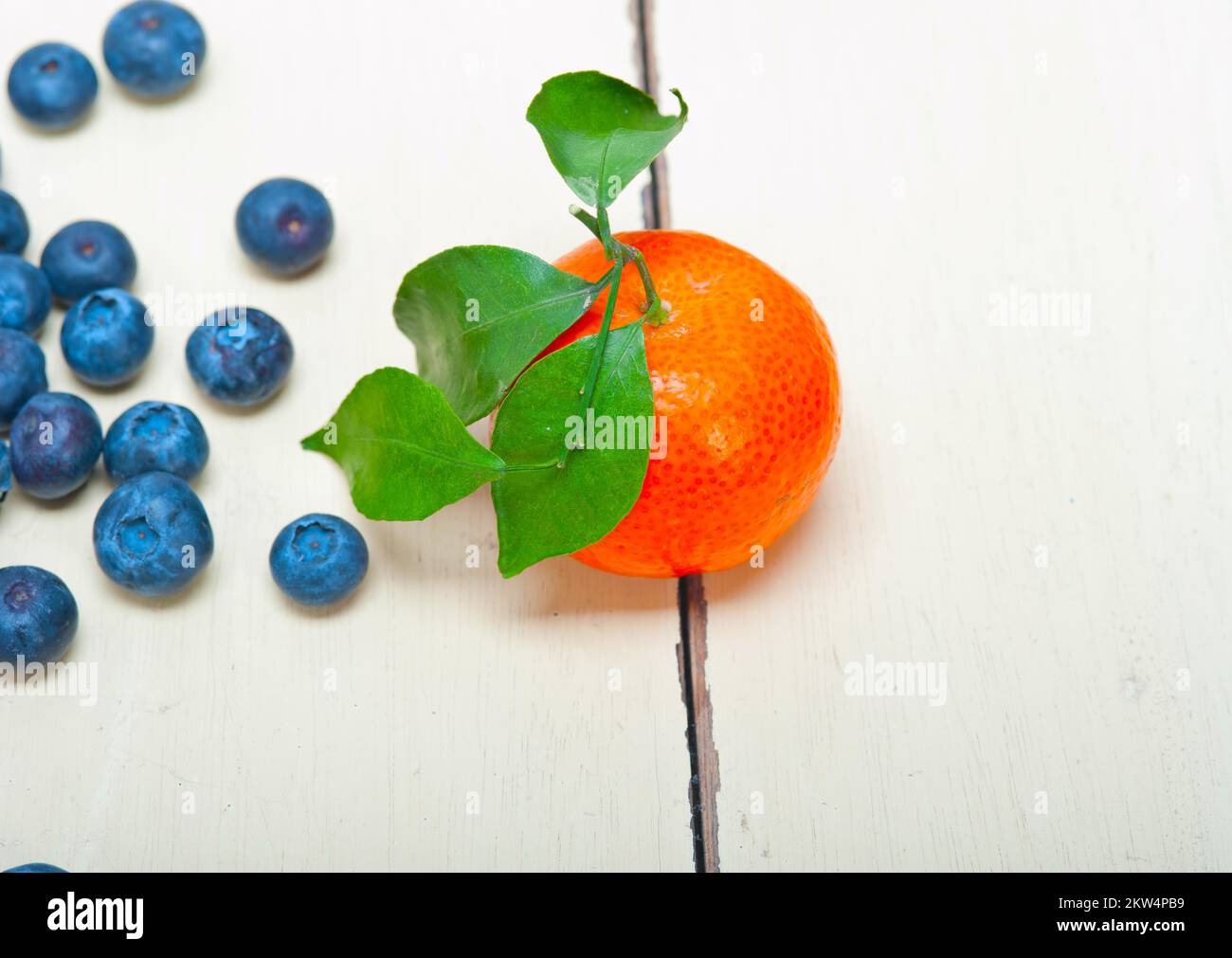 Tangerine and blueberry on white rustic wood table Stock Photo - Alamy