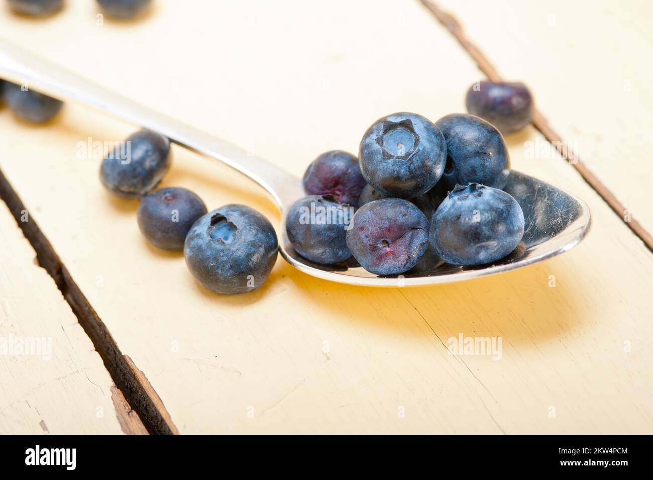 Fresh blueberry on silver spoon over a white rustic wood table Stock ...