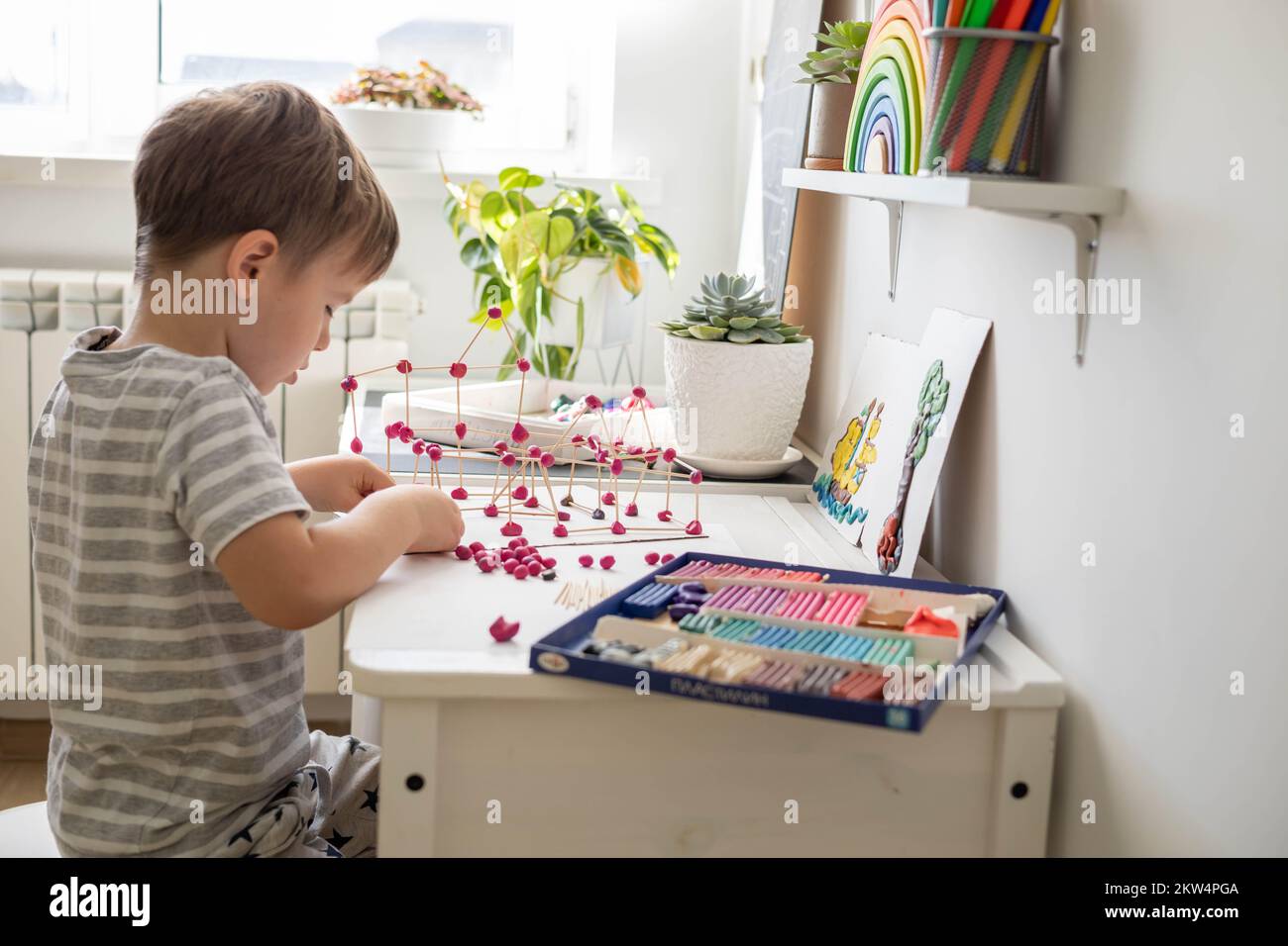 Confident cute baby boy playing and sculpt ball and toothpick design ...