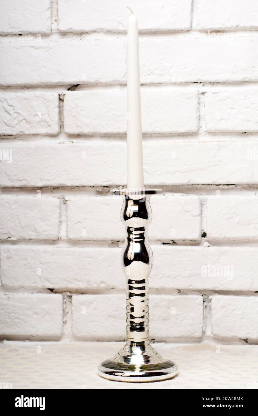 Single silver candle holder over white brick wall background Stock ...