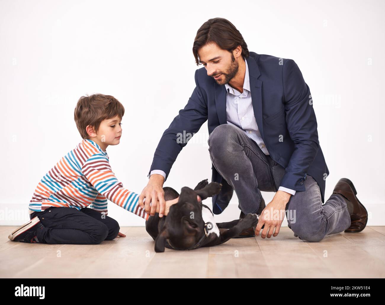 Teaching his son respect for animals. A father and son petting a dog ...