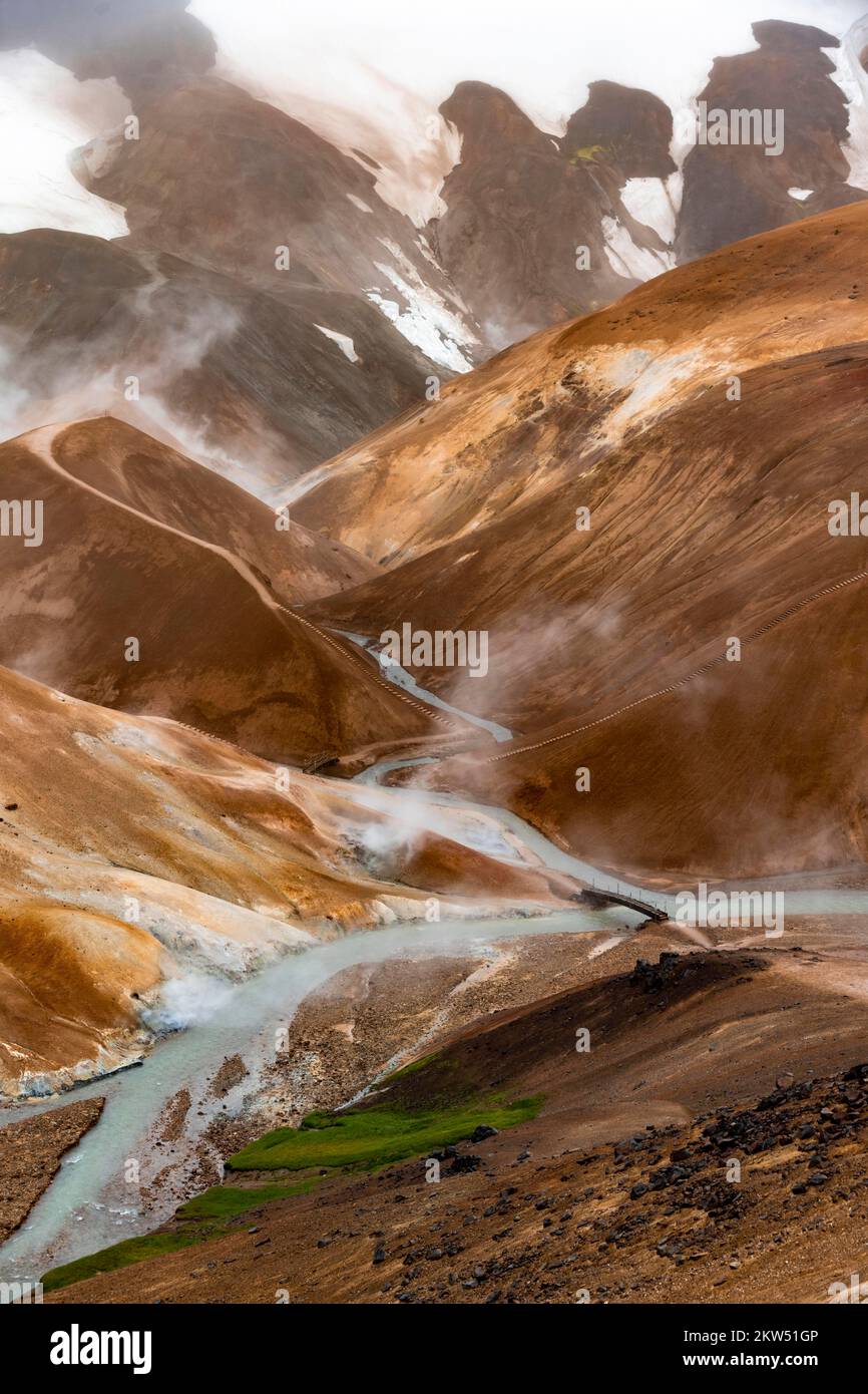 Bridge and steaming streams between colourful rhyolite mountains in the ...