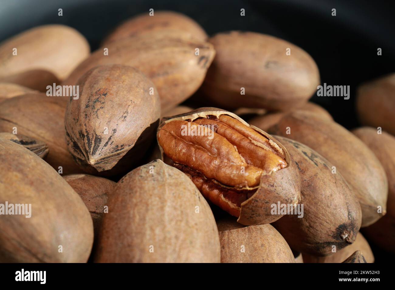 close up of pecan nuts in shell, one nut cracked, background Stock ...