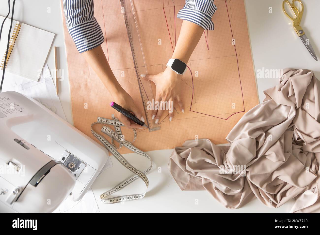 Female tailor hands draw sew pattern ruler on desk clothes creating ...