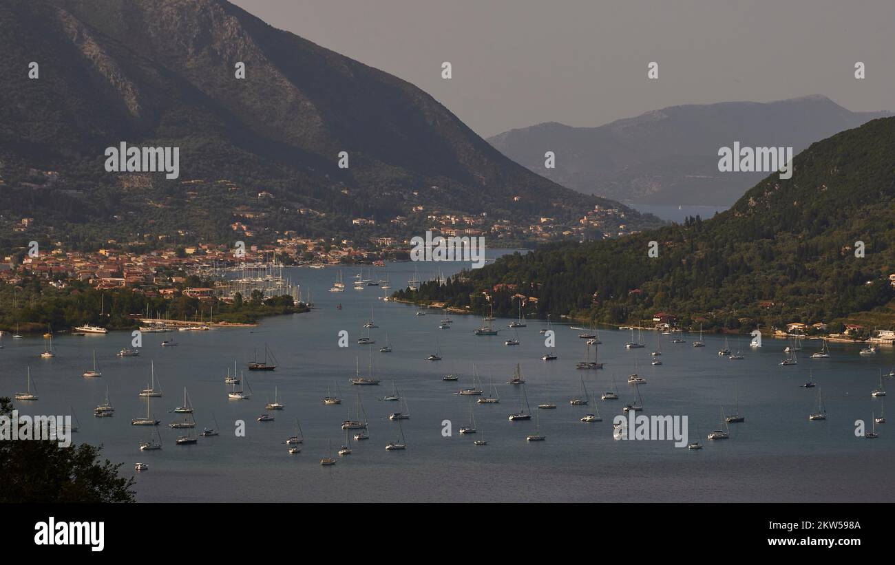 Sheltered bay, telephoto, many sailboats, blue sky, green mountain ...