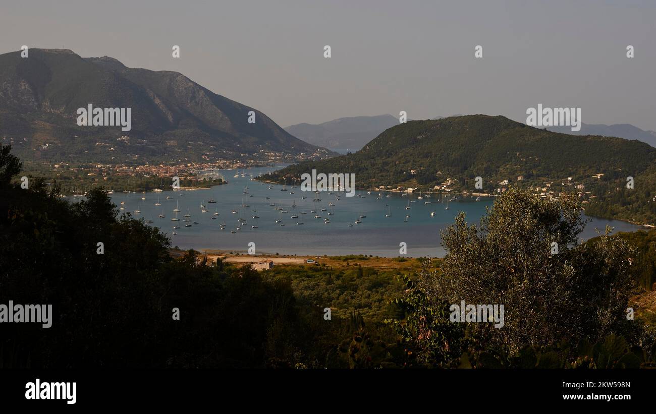 Sheltered bay, many sailboats, blue sky, green mountain slopes, Nidri ...