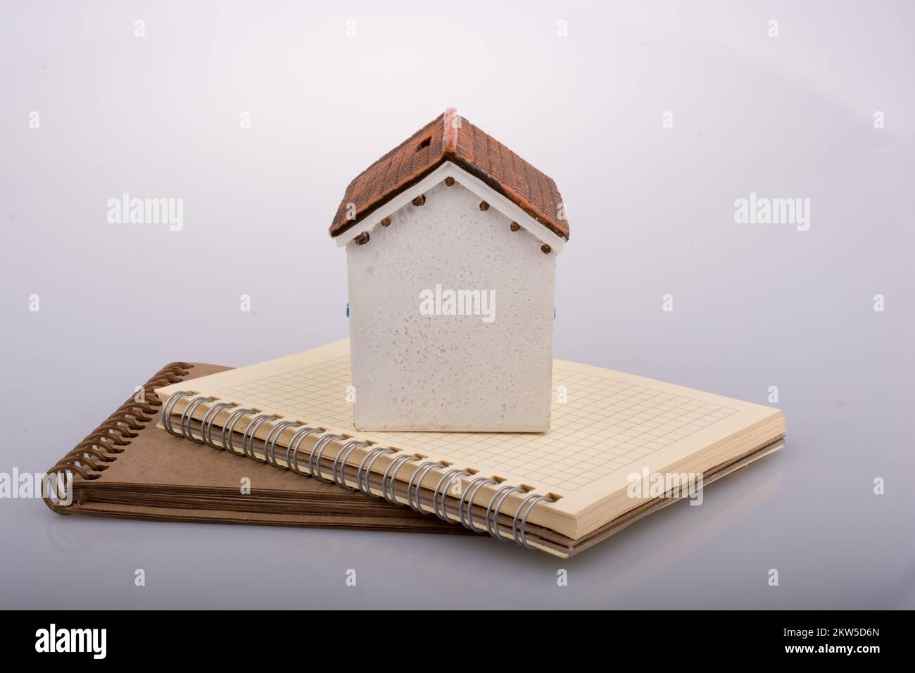 Little model house placed on an a brown color notebook Stock Photo - Alamy