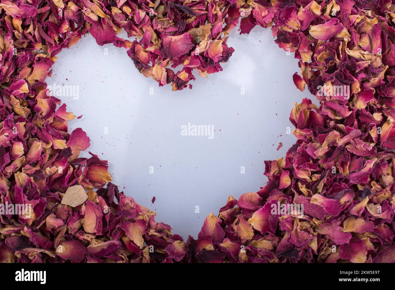 Dry petals form a heart shape on a white background Stock Photo - Alamy