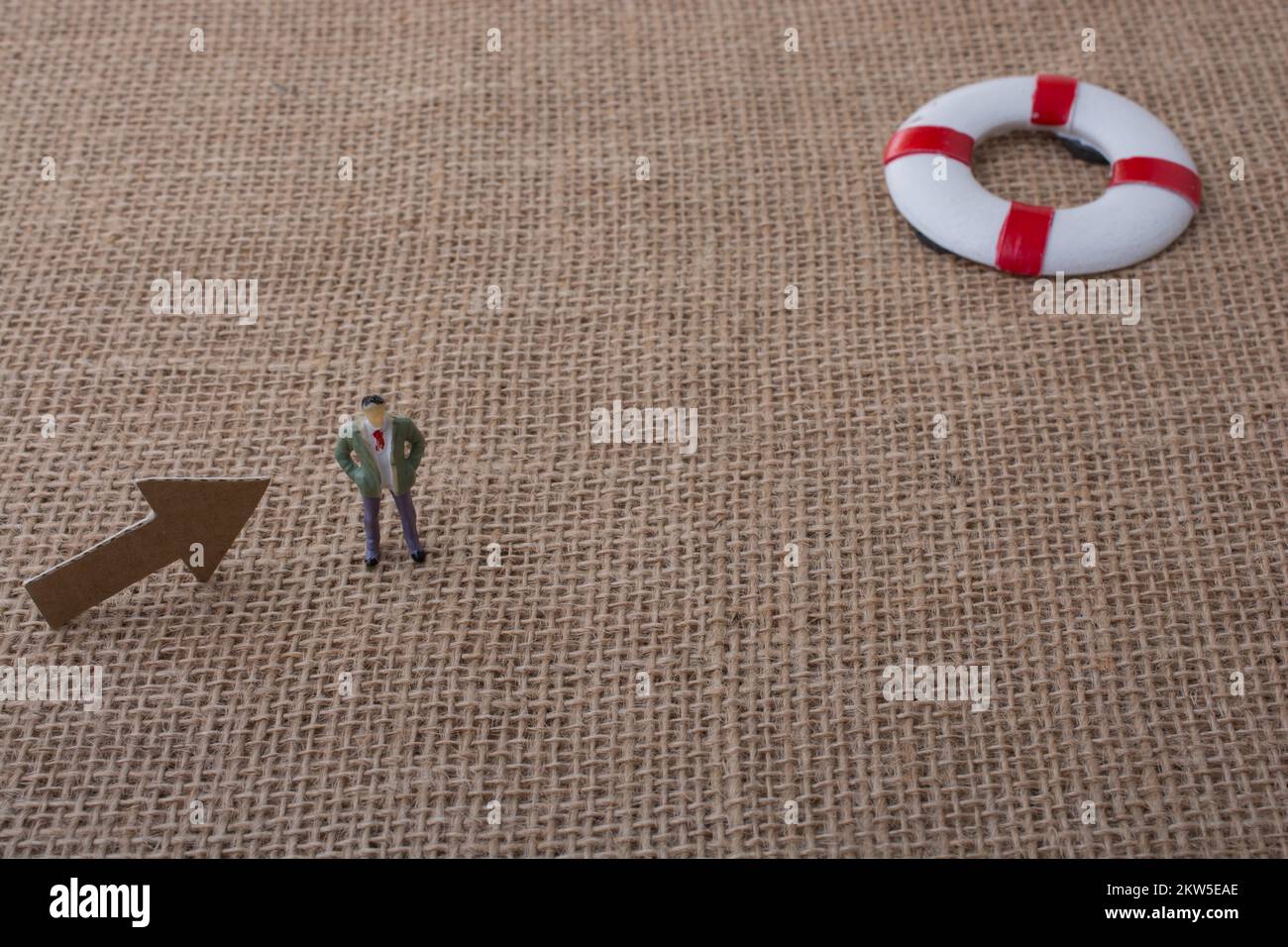 Man figurine led by an arrow to Life preserver on canvas Stock Photo ...