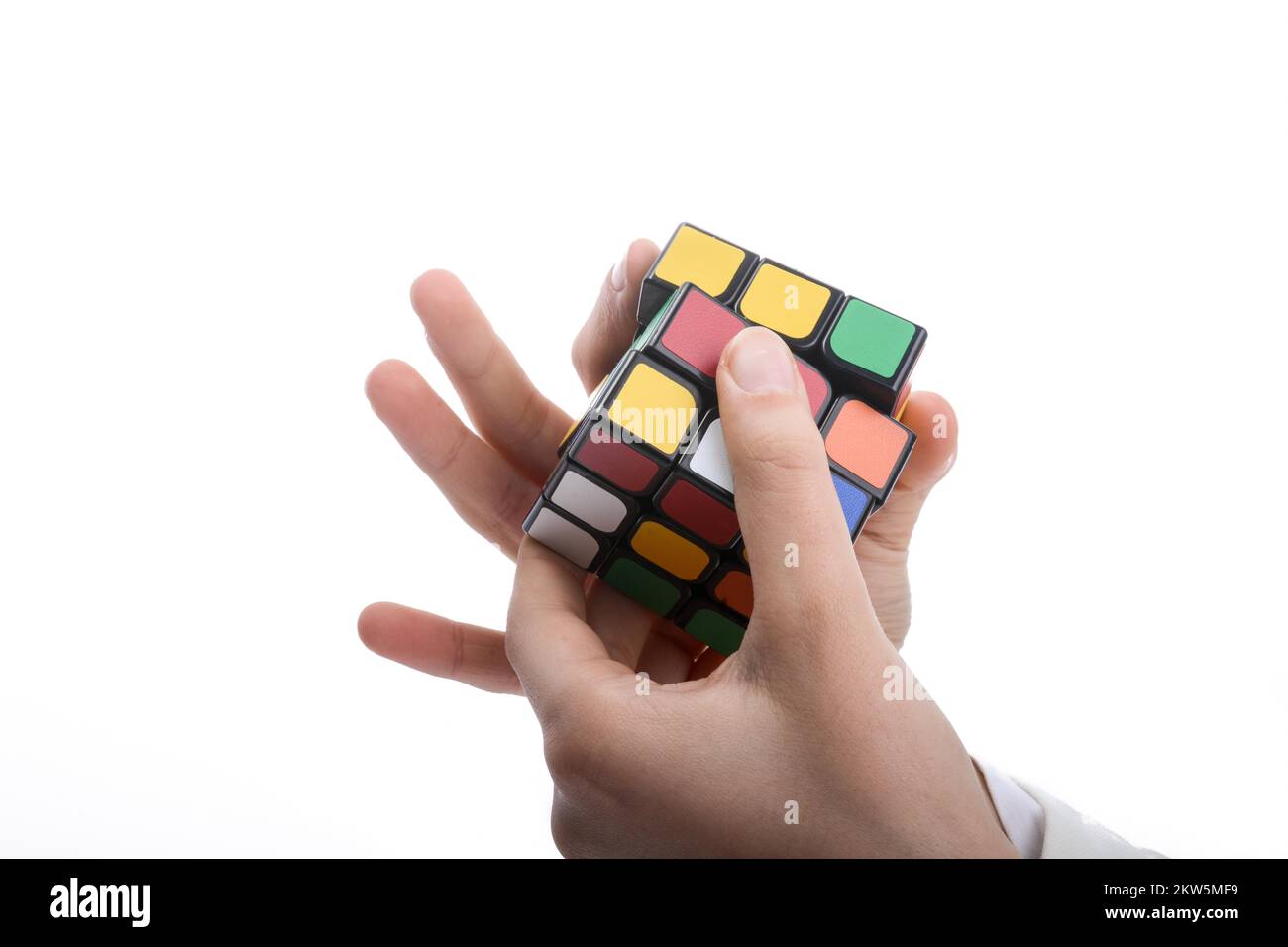 Child holding a Rubik's cube in hand on a white background Stock Photo - Alamy