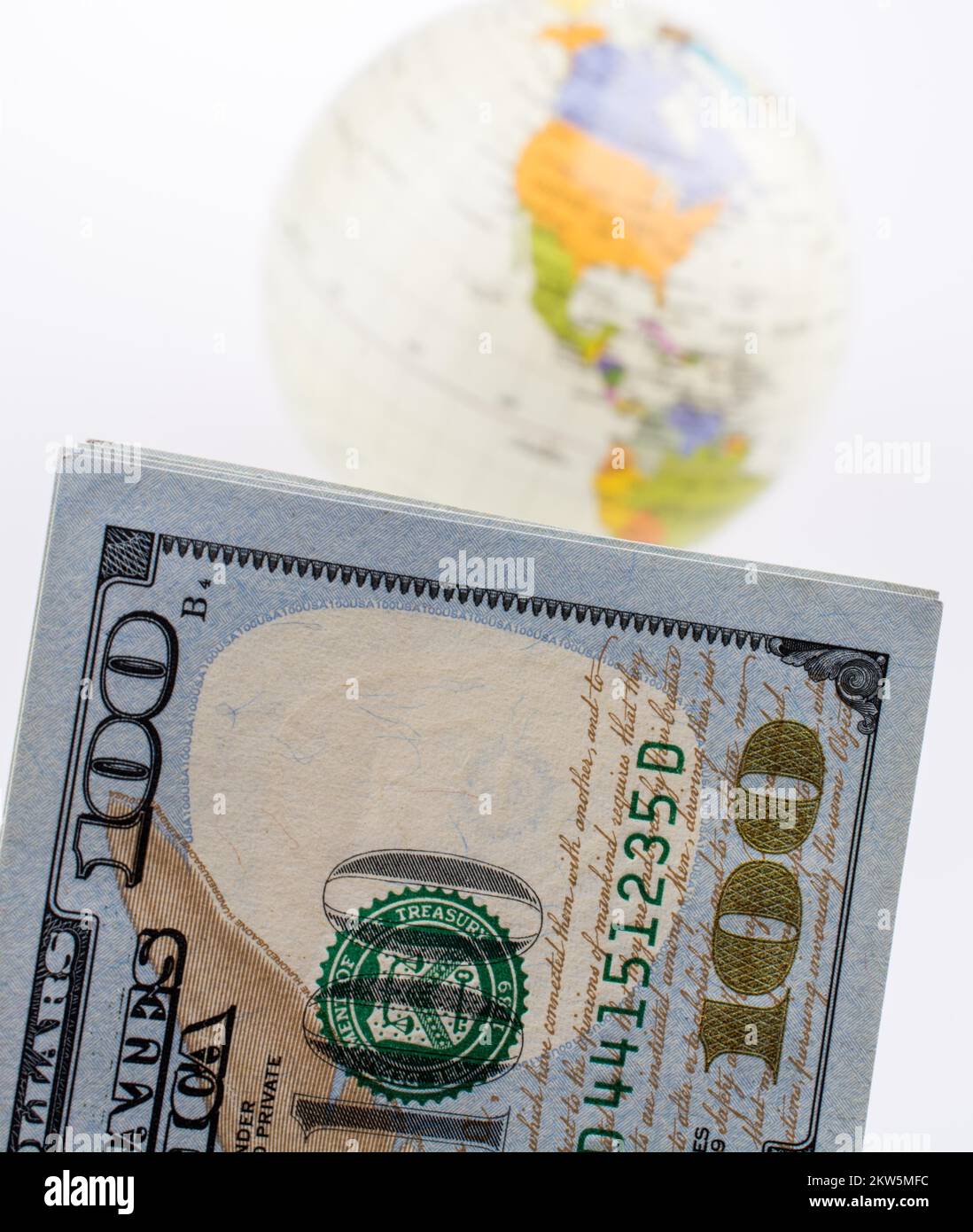 American dollar banknotes by the side of a model globe on white ...