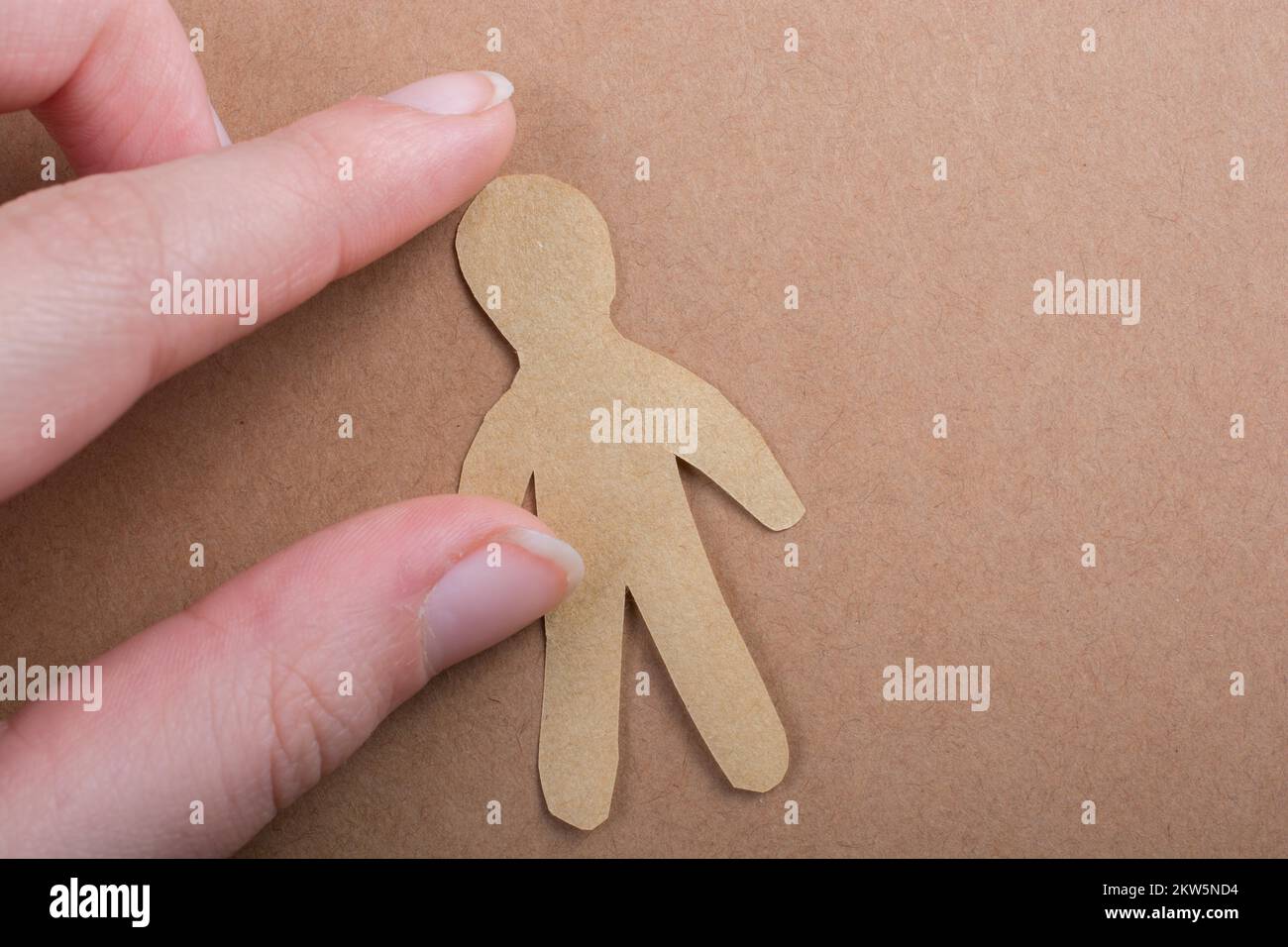 Man shape cut out of paper in hand in the view Stock Photo - Alamy