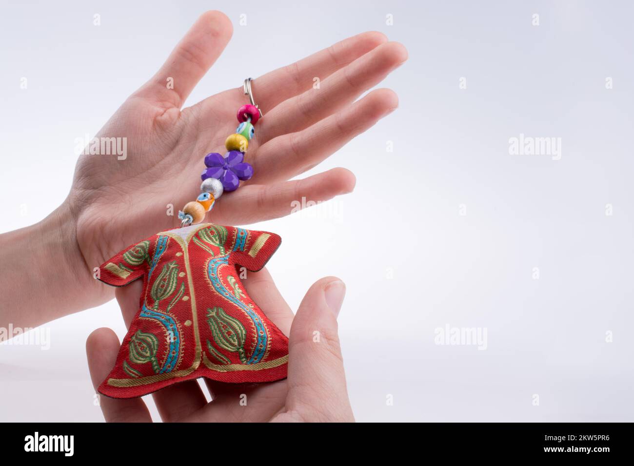 Hand holding traditional clothes with ornaments Stock Photo - Alamy
