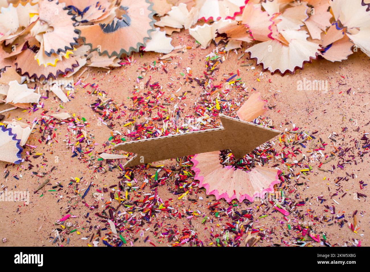 Arrow cut out of paper amid pencil shavings on canvas Stock Photo - Alamy