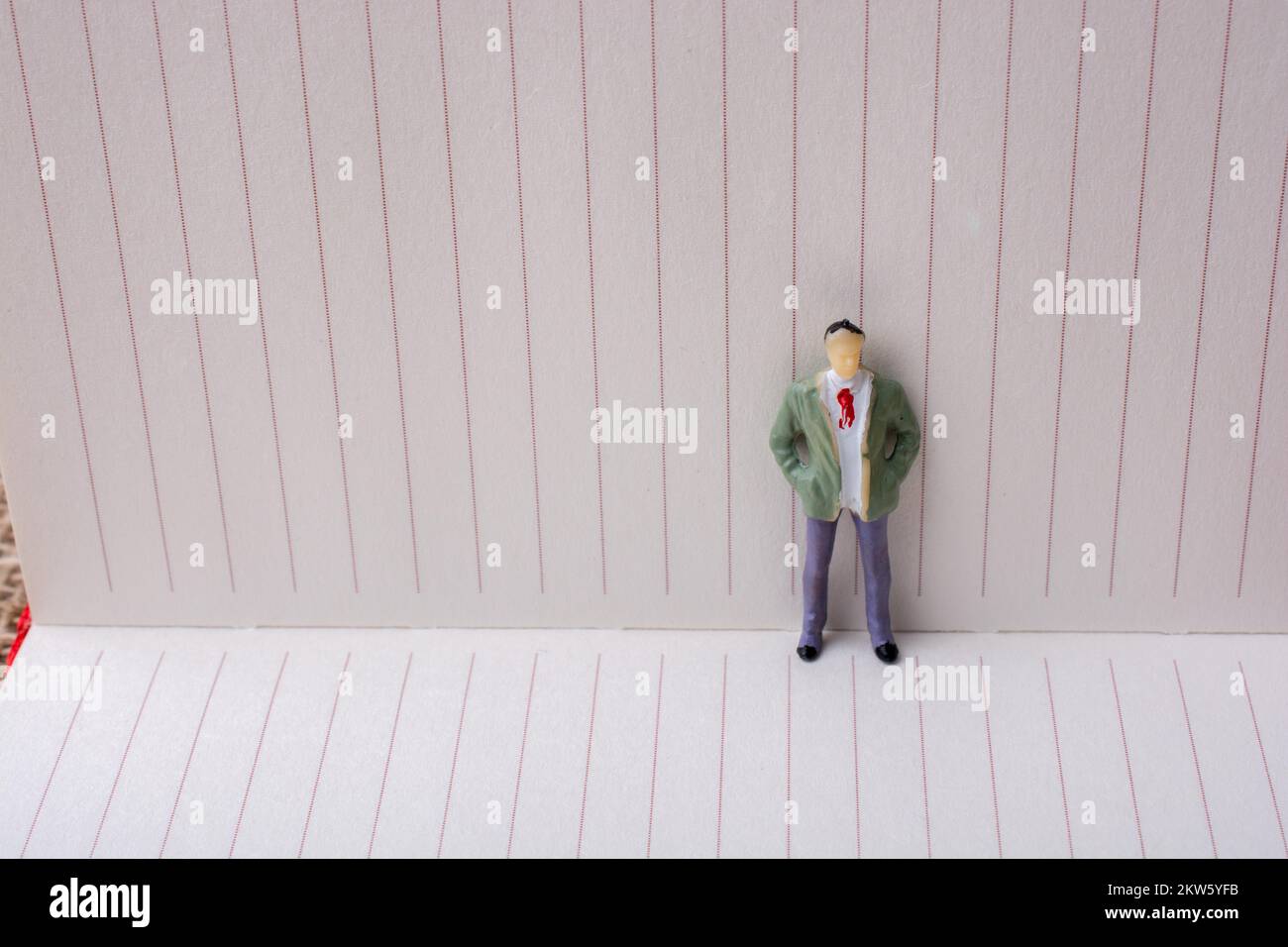 Figurine and an paper arrow in a notebook on canvas Stock Photo - Alamy