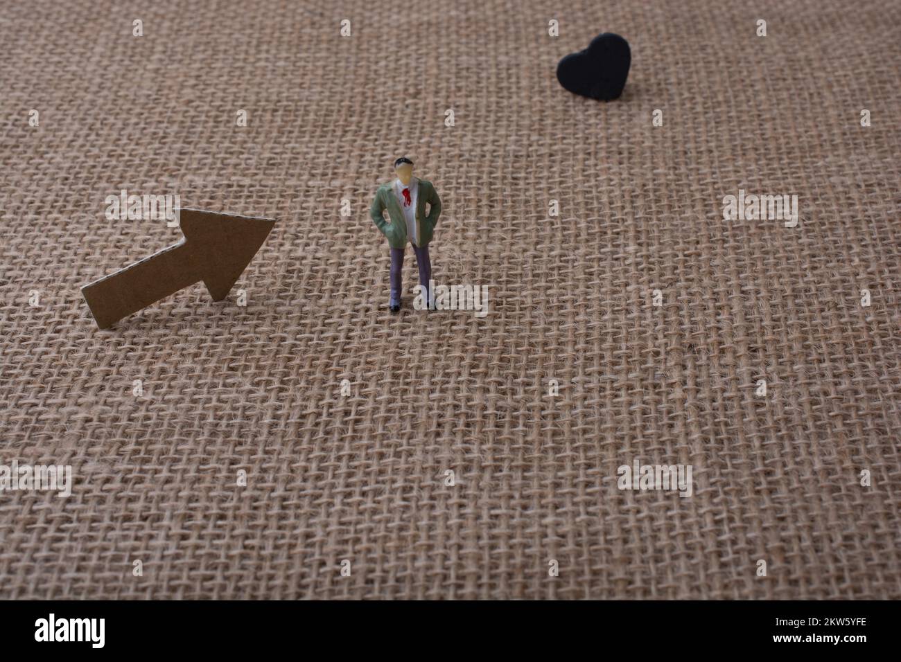 Figurine and arrow sign cut out of brown paper on canvas Stock Photo ...