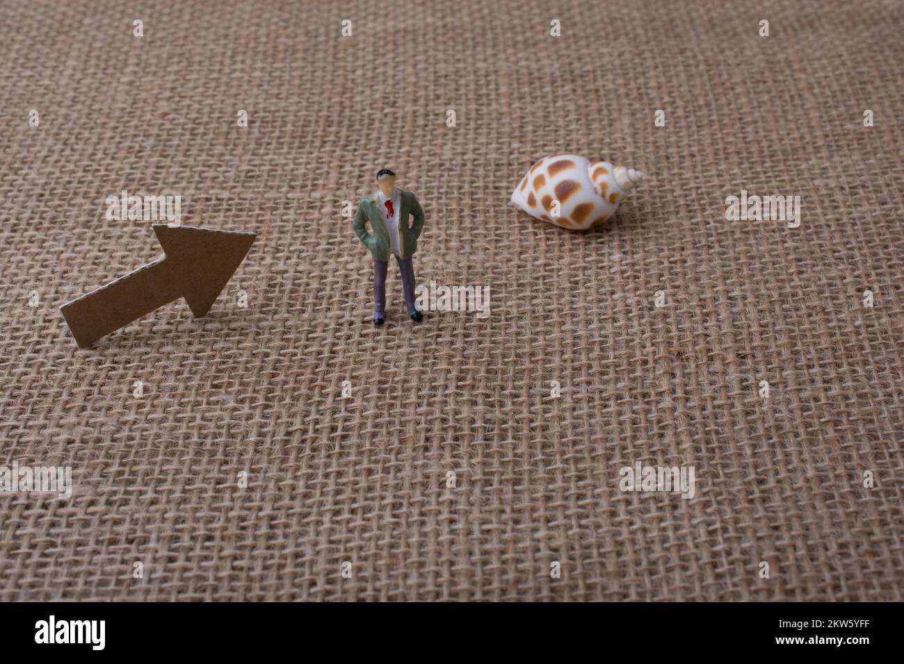 Figurine and arrow sign cut out of brown paper on canvas Stock Photo ...
