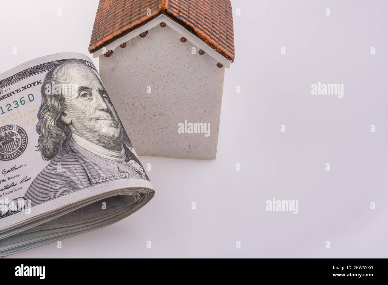 Human hand holding American dollar banknotes by the side of a model ...