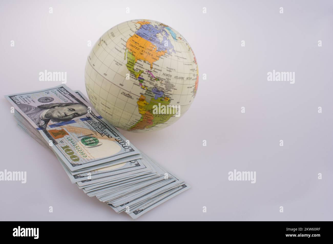 American dollar banknotes by the side of a model globe on white ...