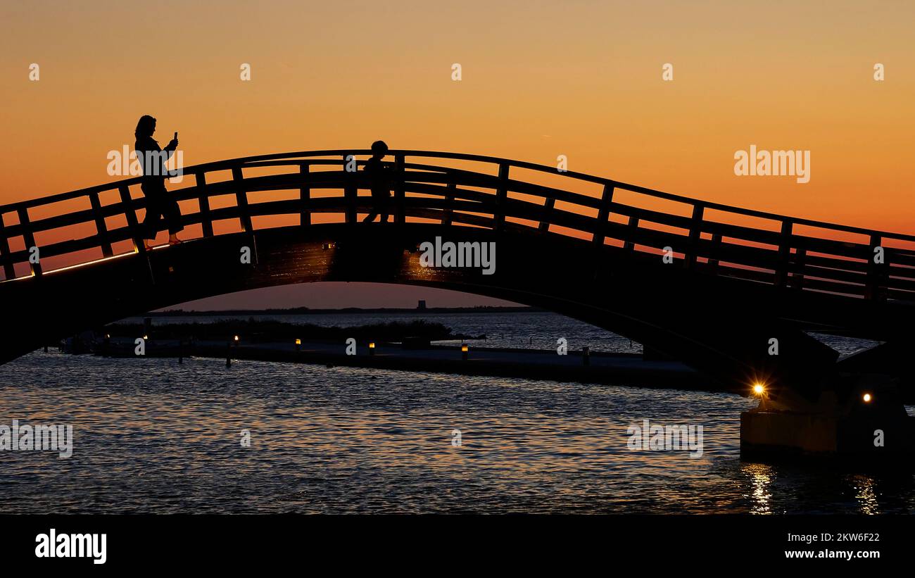 Dusk, sunset, wooden bridge, footbridge over canal, silhouette ...