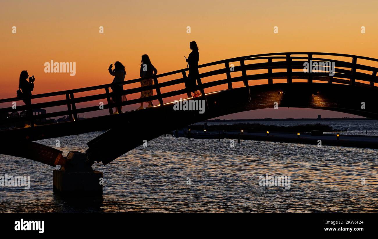 Dusk, sunset, wooden bridge, footbridge over canal, silhouette ...