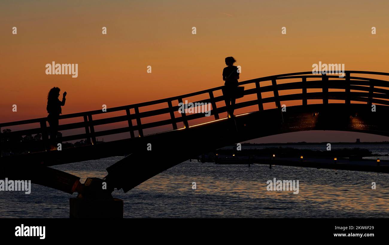 Dusk, sunset, wooden bridge, footbridge over canal, silhouette ...