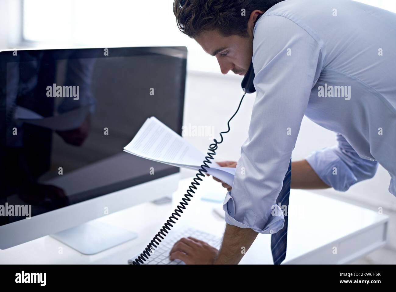 On the phone with an important client. A young businessman looking at a ...