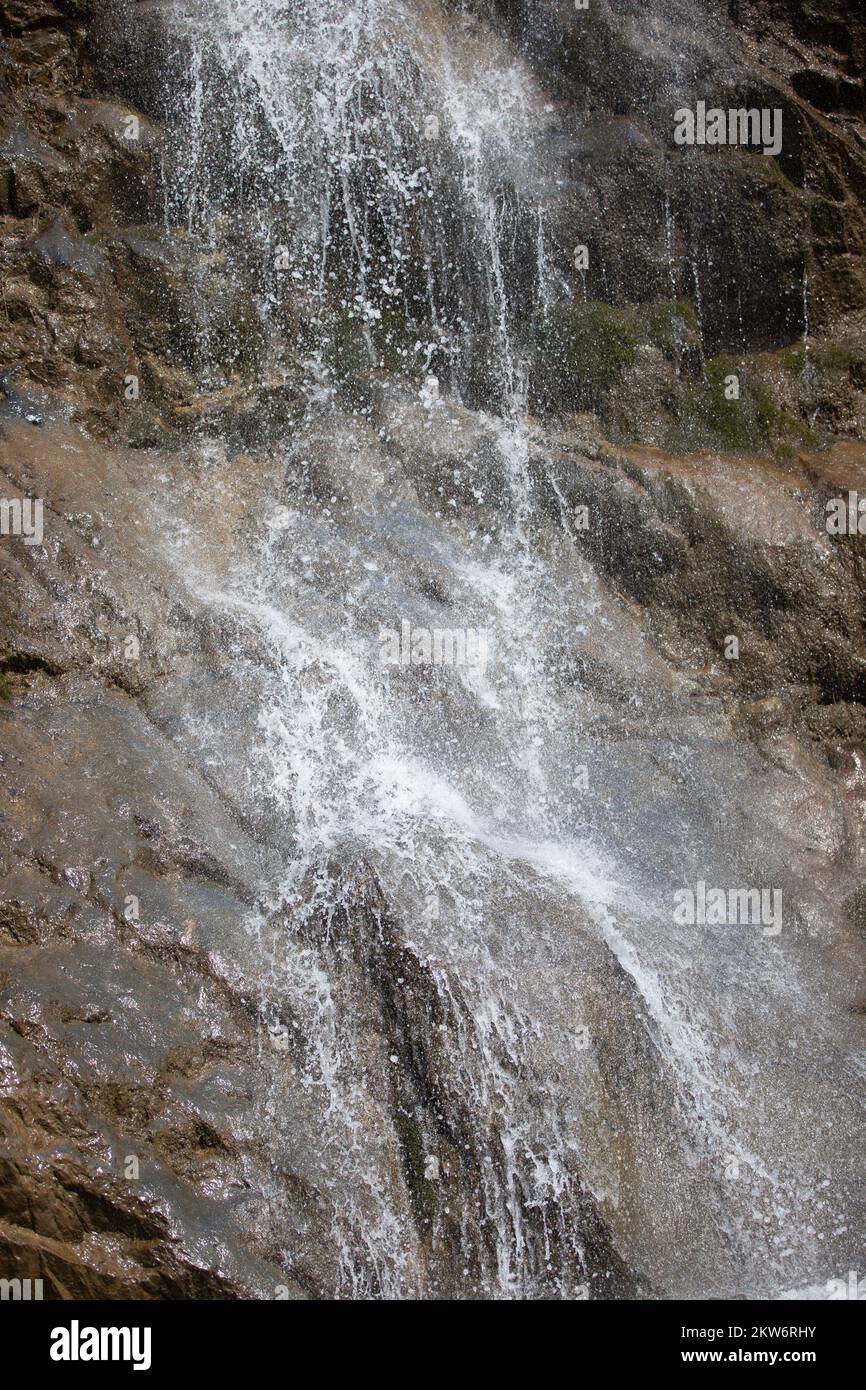 Beautiful waterfall in the mountains. Water flows down from the ...