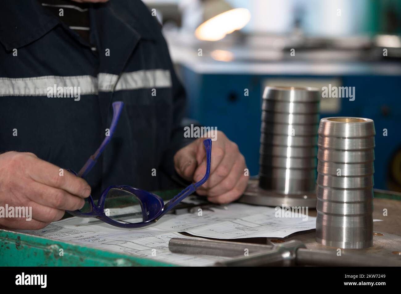 Turning shop or production. Worker's hands hold a metal product ...