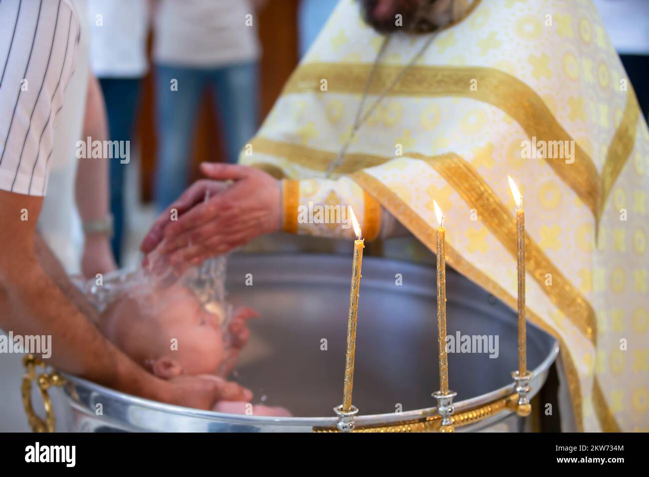 Blurred rite of Orthodox baptism against the background of burning ...