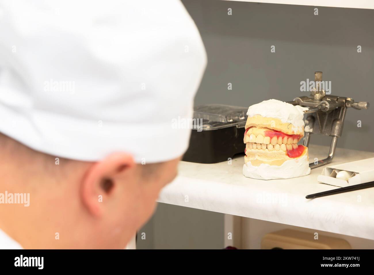 Manufacturing of dentures. Orthopedist prosthetist at the workplace ...