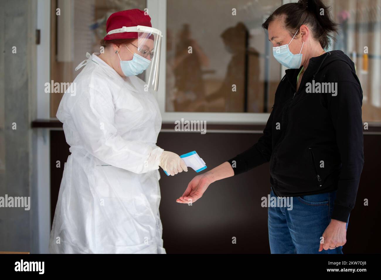 A doctor uses an outdoor thermometer gun to check body temperature for ...