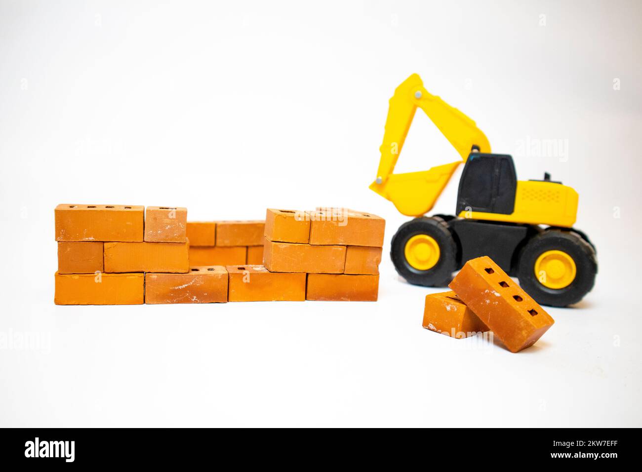 children's construction site excavator and bricks on a white background ...