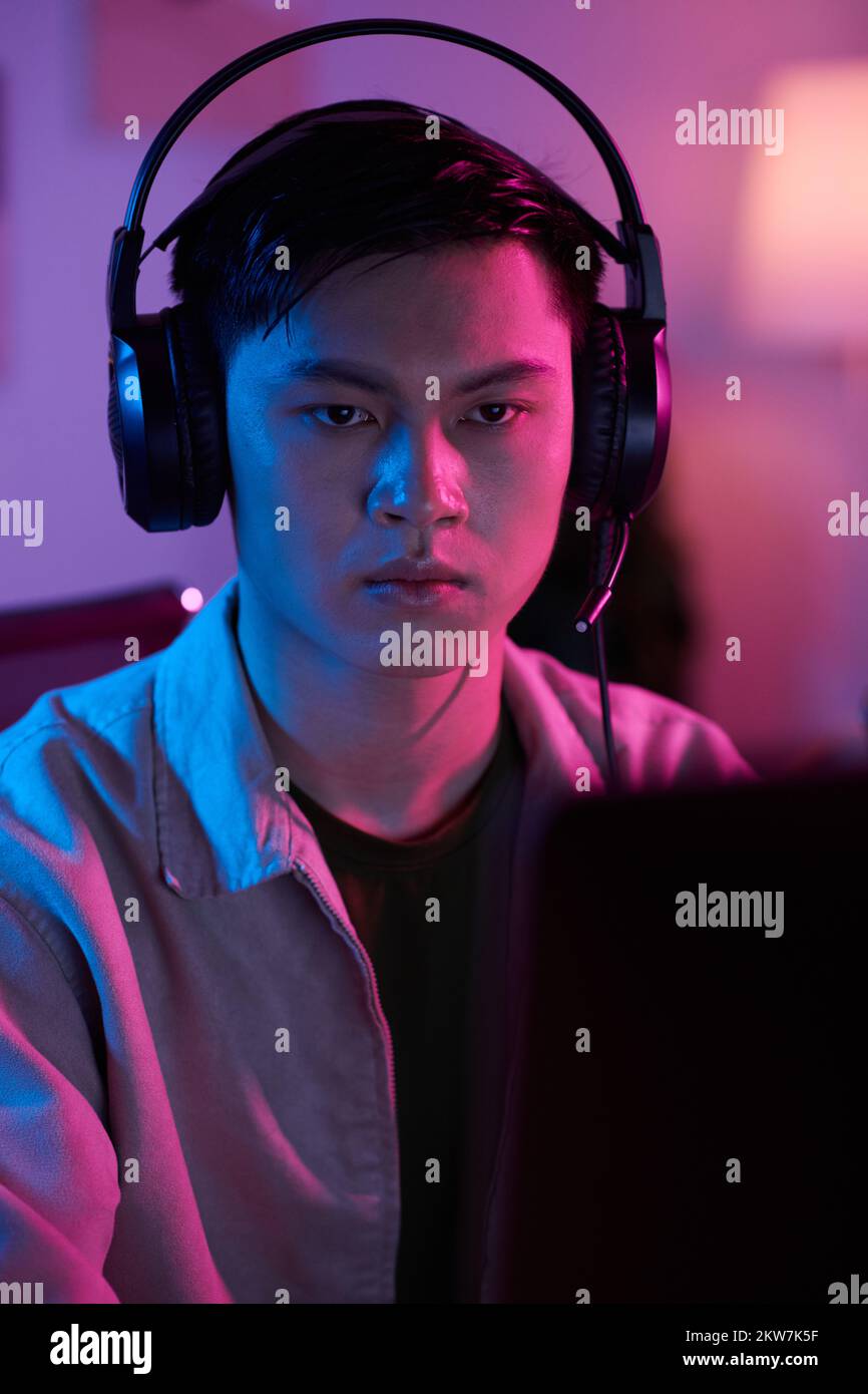 Serious teenage boy wearing headphones when playing video game Stock ...